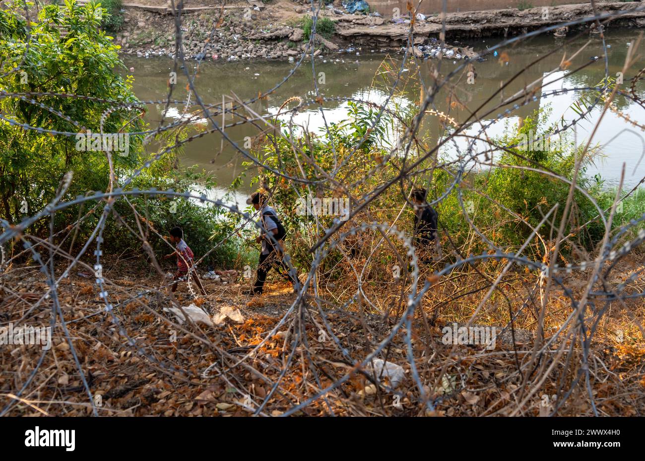 Illegal Burmese immigrants crossing the Moei river on the Thai side of the Thailand-Myanmar ...