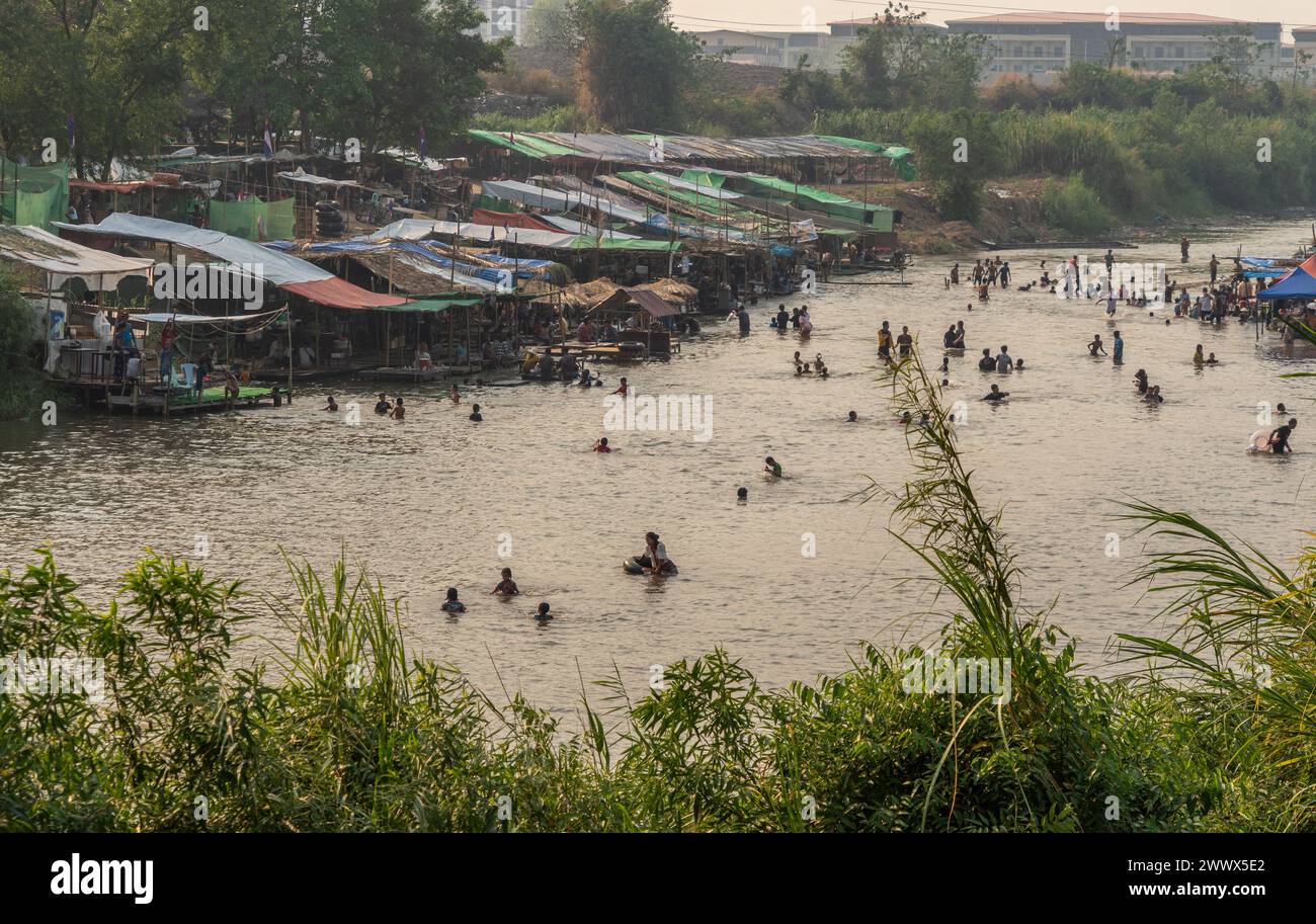 Thai and Burmese families swimming and playing in the Thailand-Myanmar ...