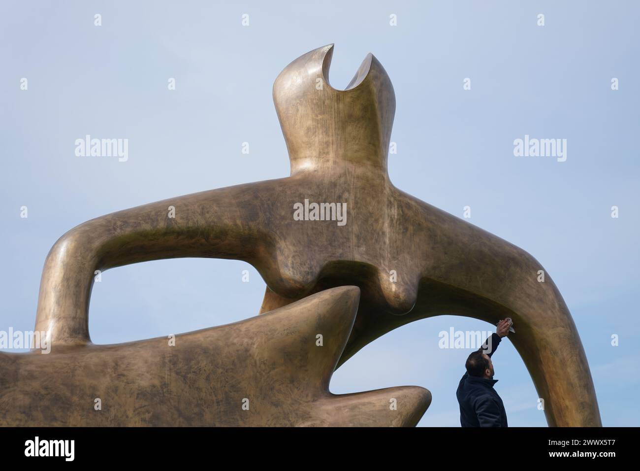 Art technician Dai Roberts cleans the bronze sculpture Large Reclining ...