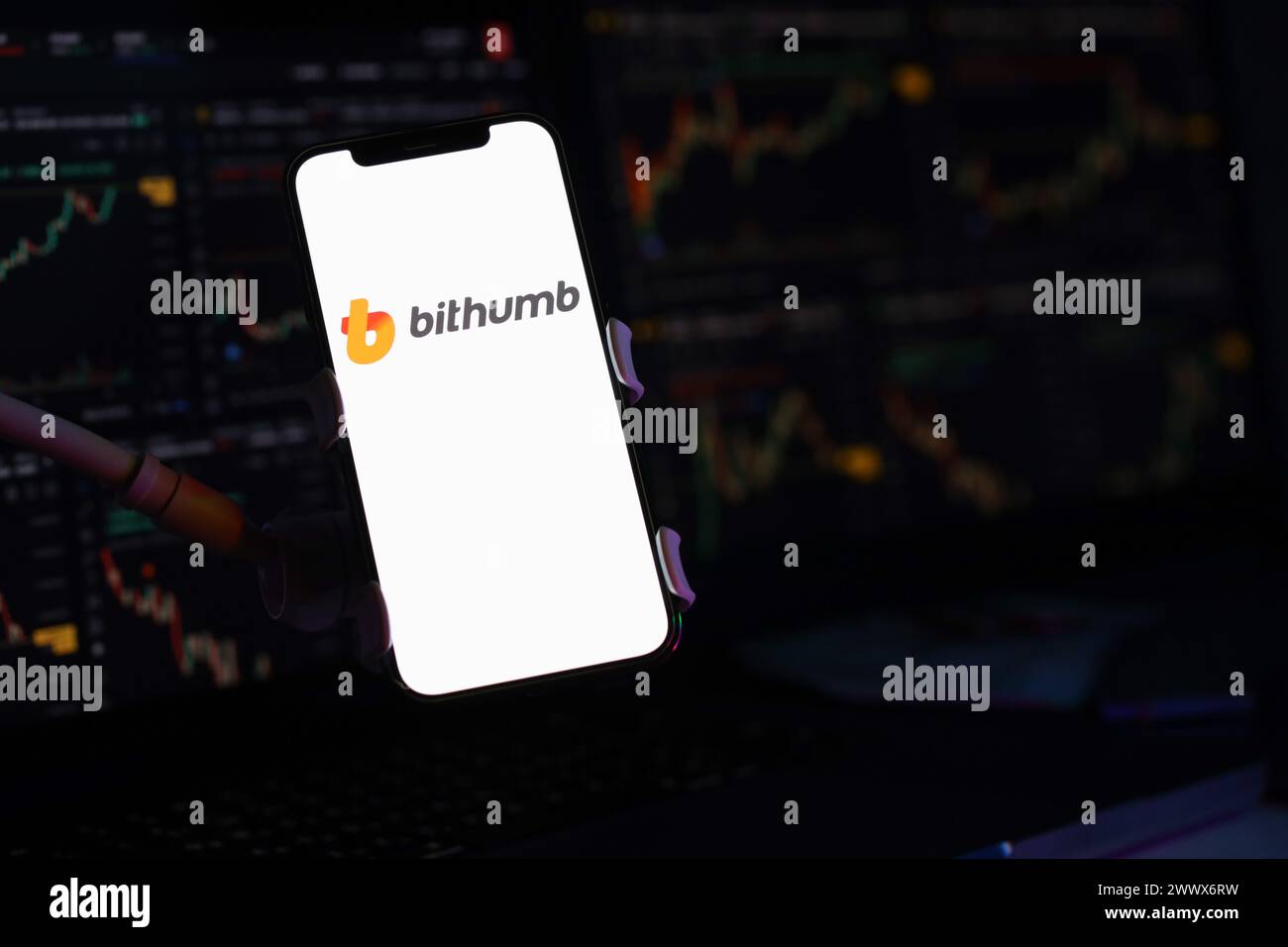 KYIV, UKRAINE - MARCH 15, 2024 Bithumb logo on iPhone display screen and crypto currency value ...