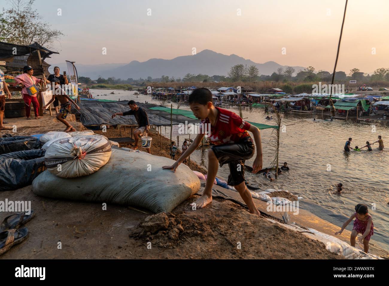 Thai and Burmese families swimming and playing in the Thailand-Myanmar ...