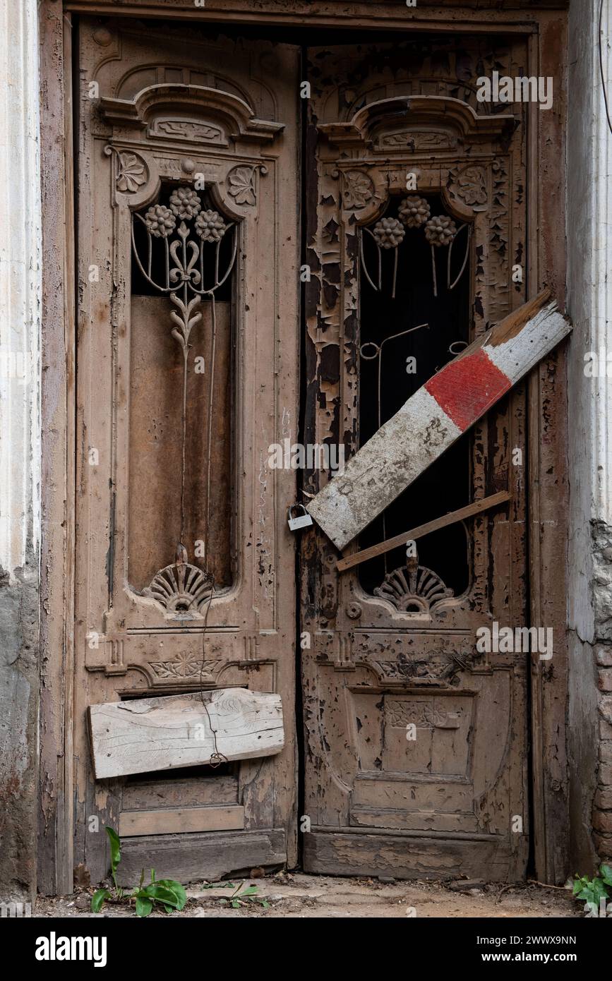 Old, broken, wooden doors at the entrance to a condemned building in ...