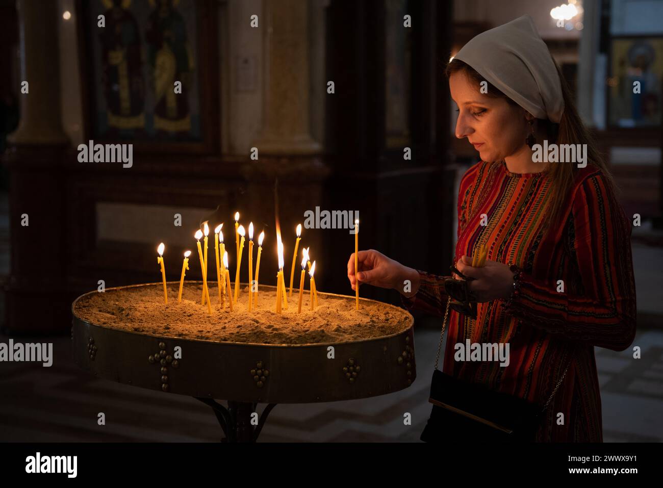 Worshippers light candles and recite prayers in the sanctuary of the ...