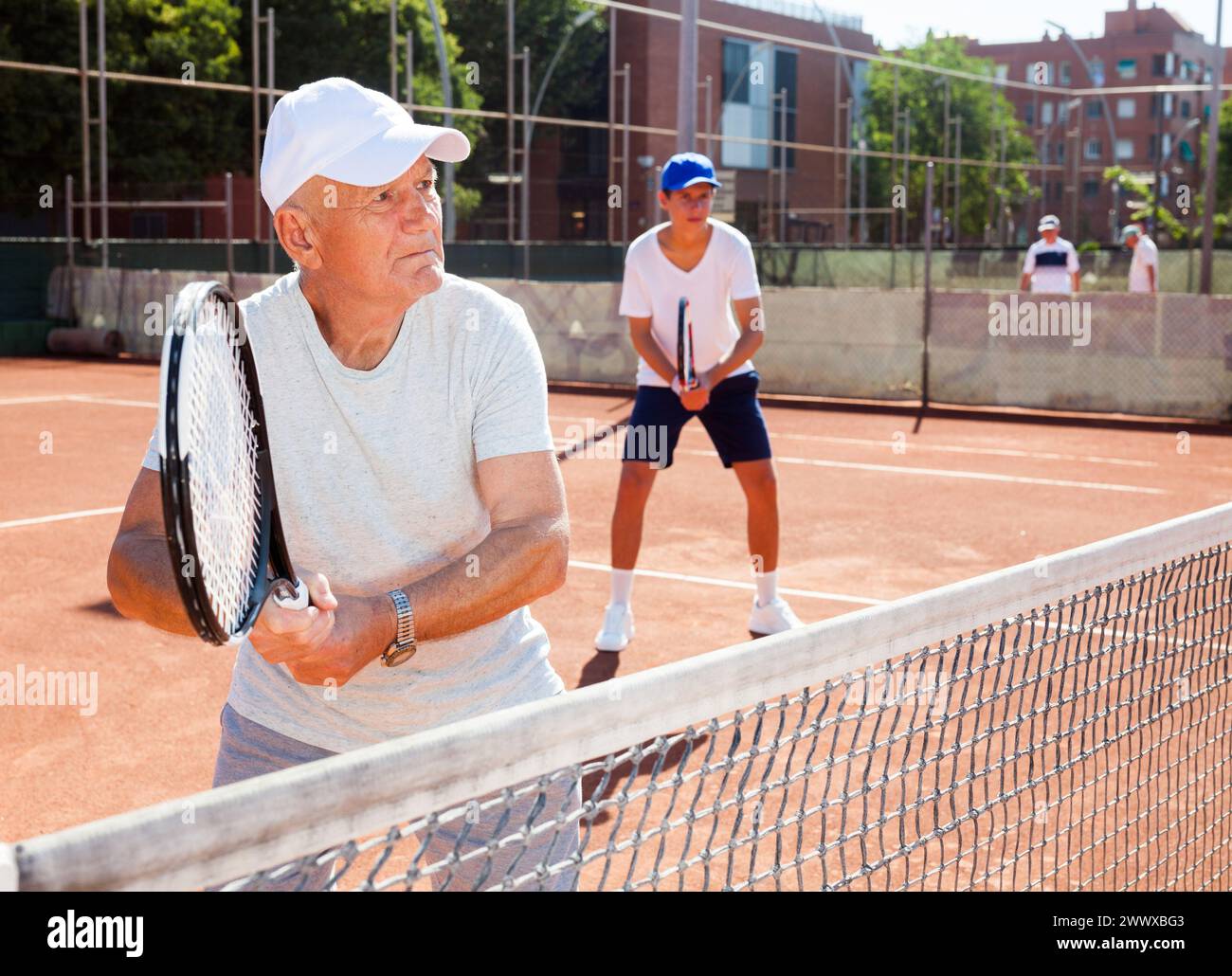 Tennis players of different generations playing tennis court Stock ...