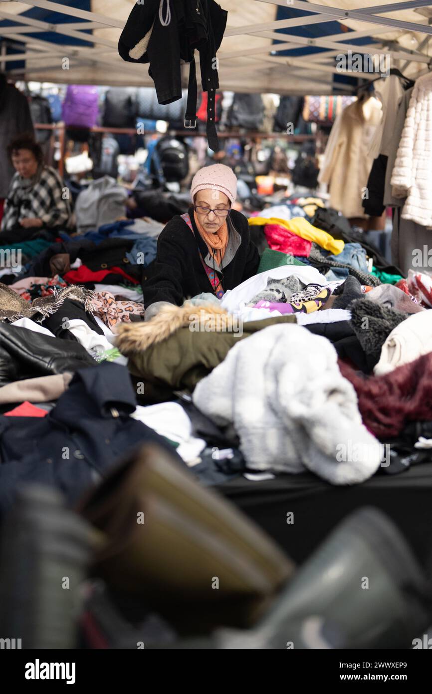 church street market - Elderly woman sorting through a pile of used ...
