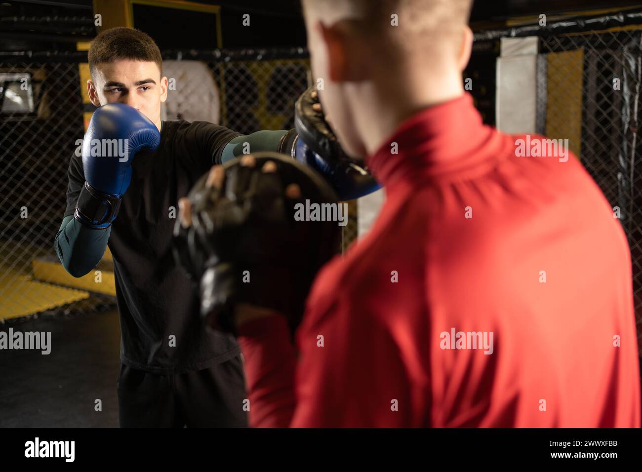 Boxing athlete punch to his opponent in sparring. Two male boxers ...