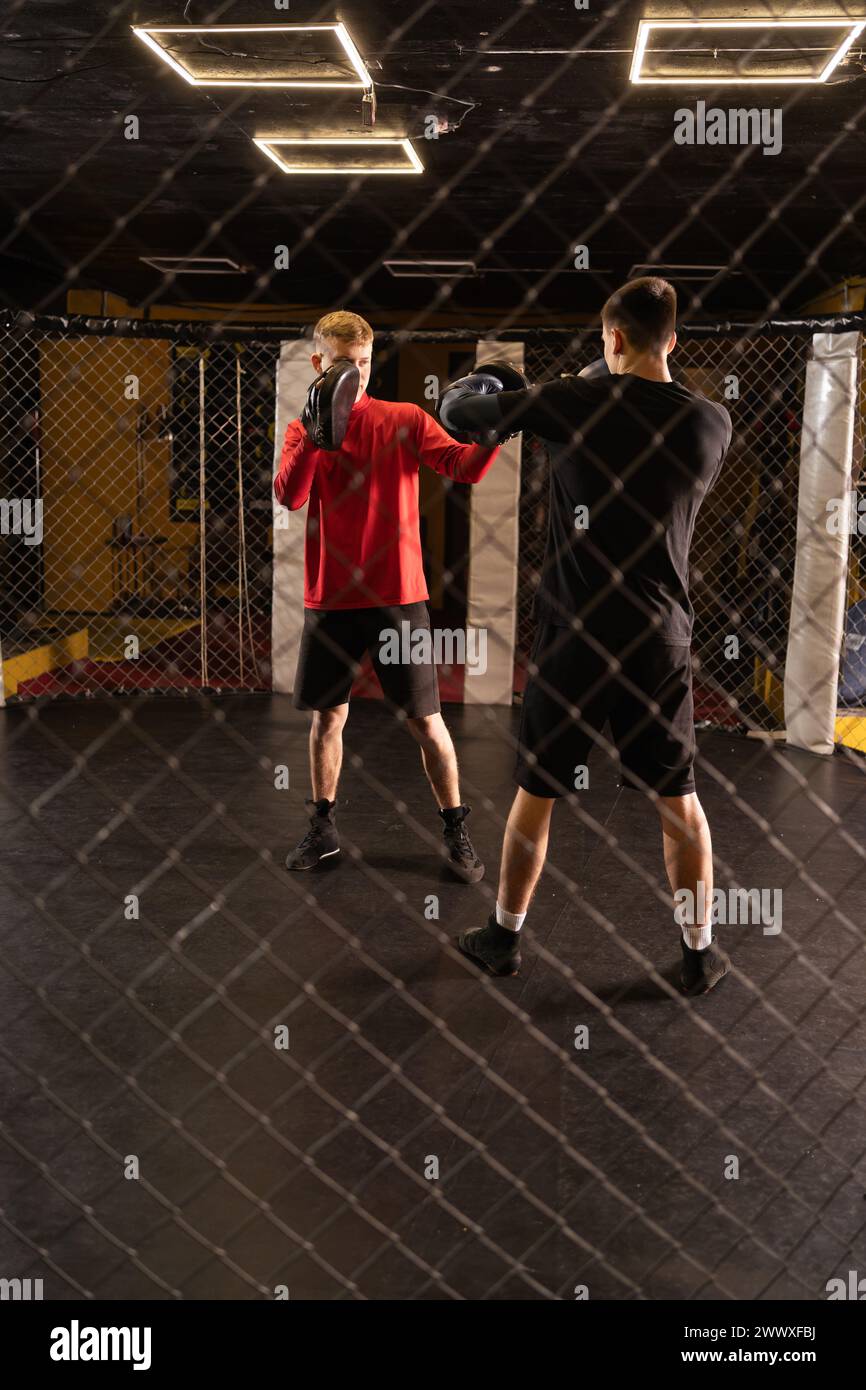 Two young professional boxer boxing in gym cage Stock Photo - Alamy