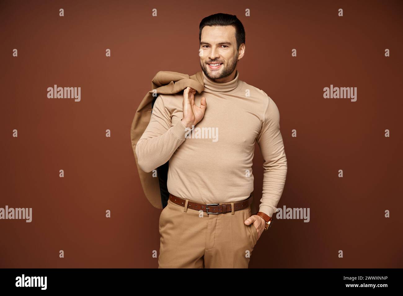 happy man in turtleneck holding his jacket over shoulder and posing ...