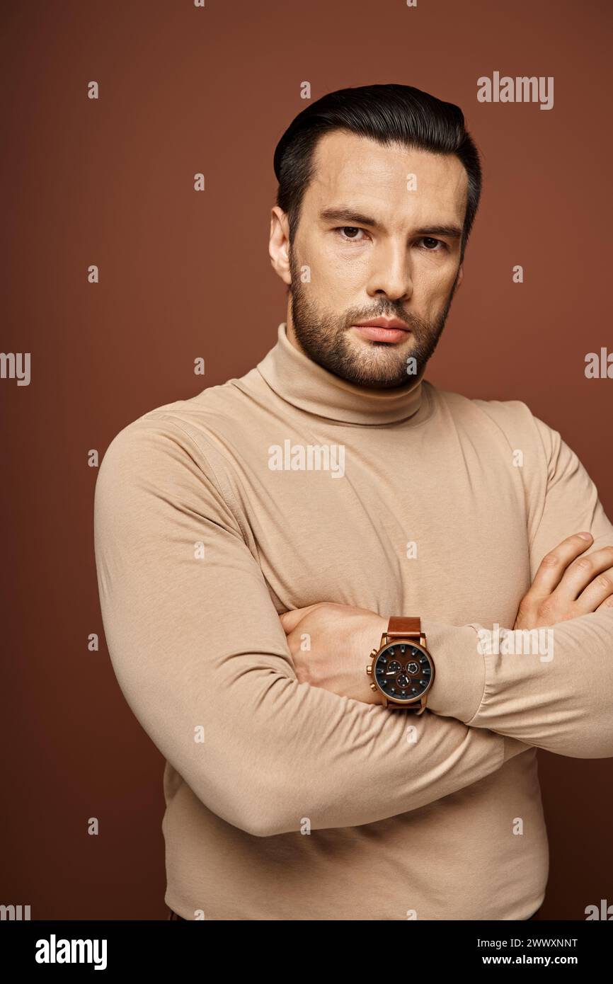 Determined and handsome man in turtleneck posing with crossed arms and ...