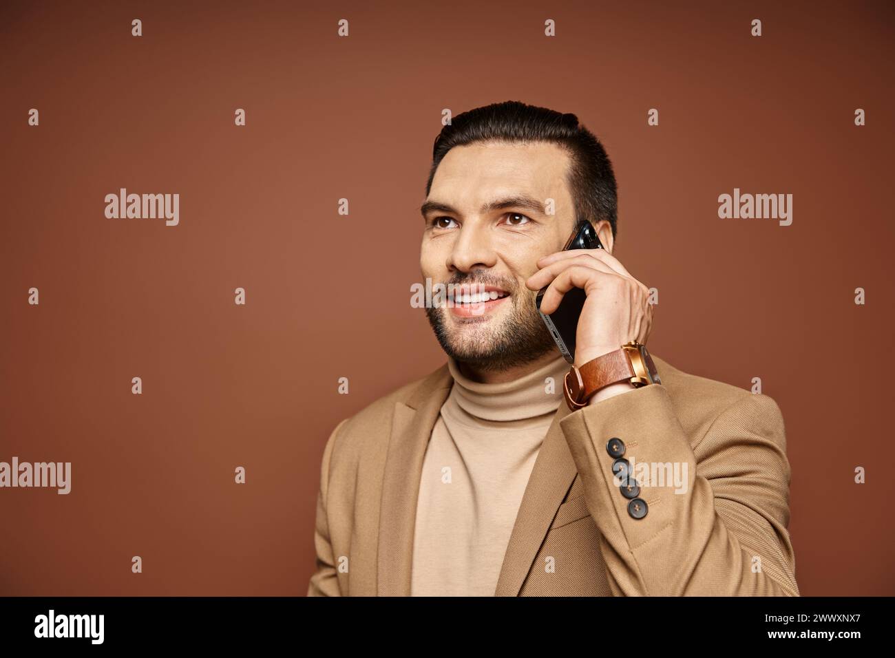 Stylish and handsome man with bristle smiling and having phone call on ...