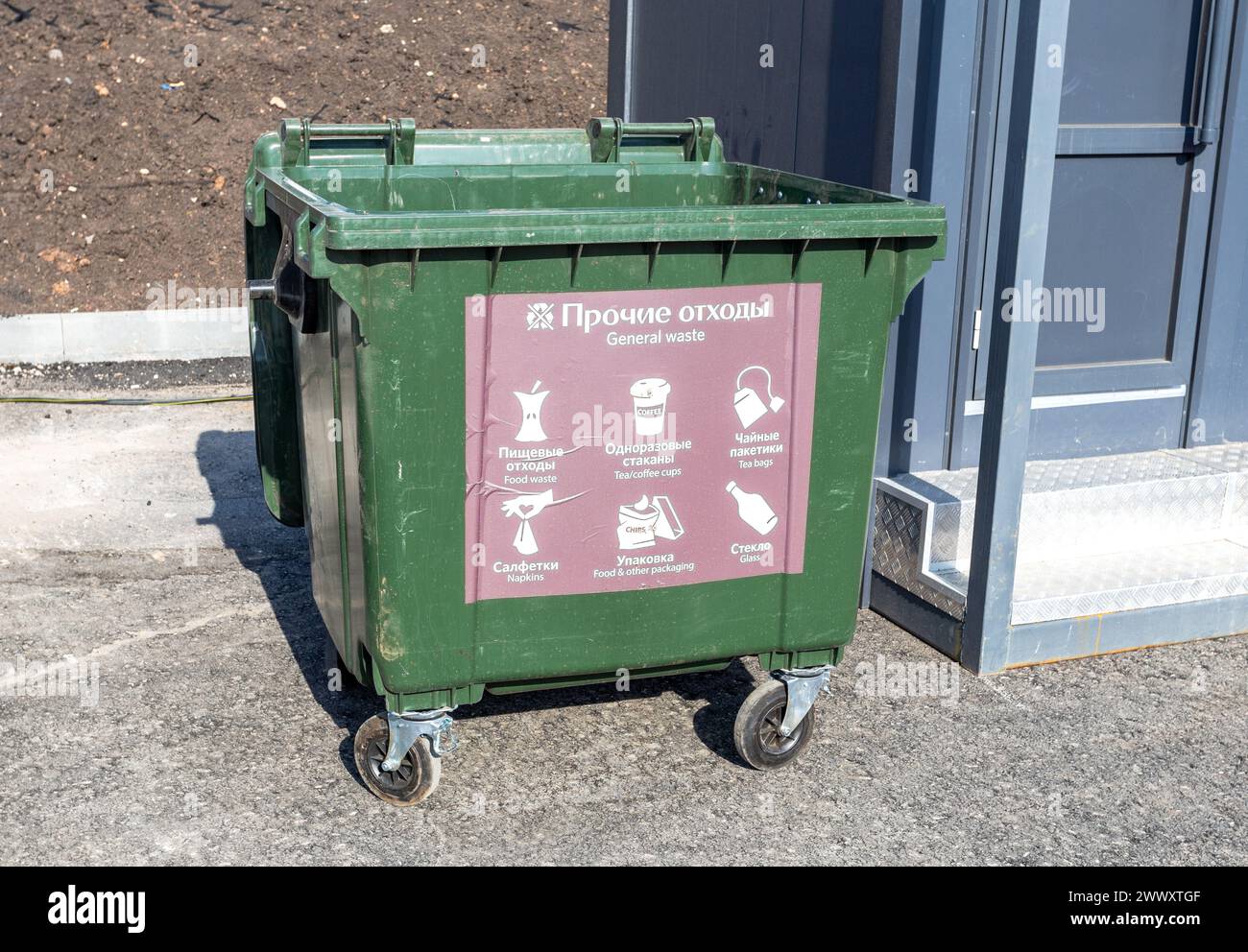 Opened big green plastic garbage container with wheels at the city ...