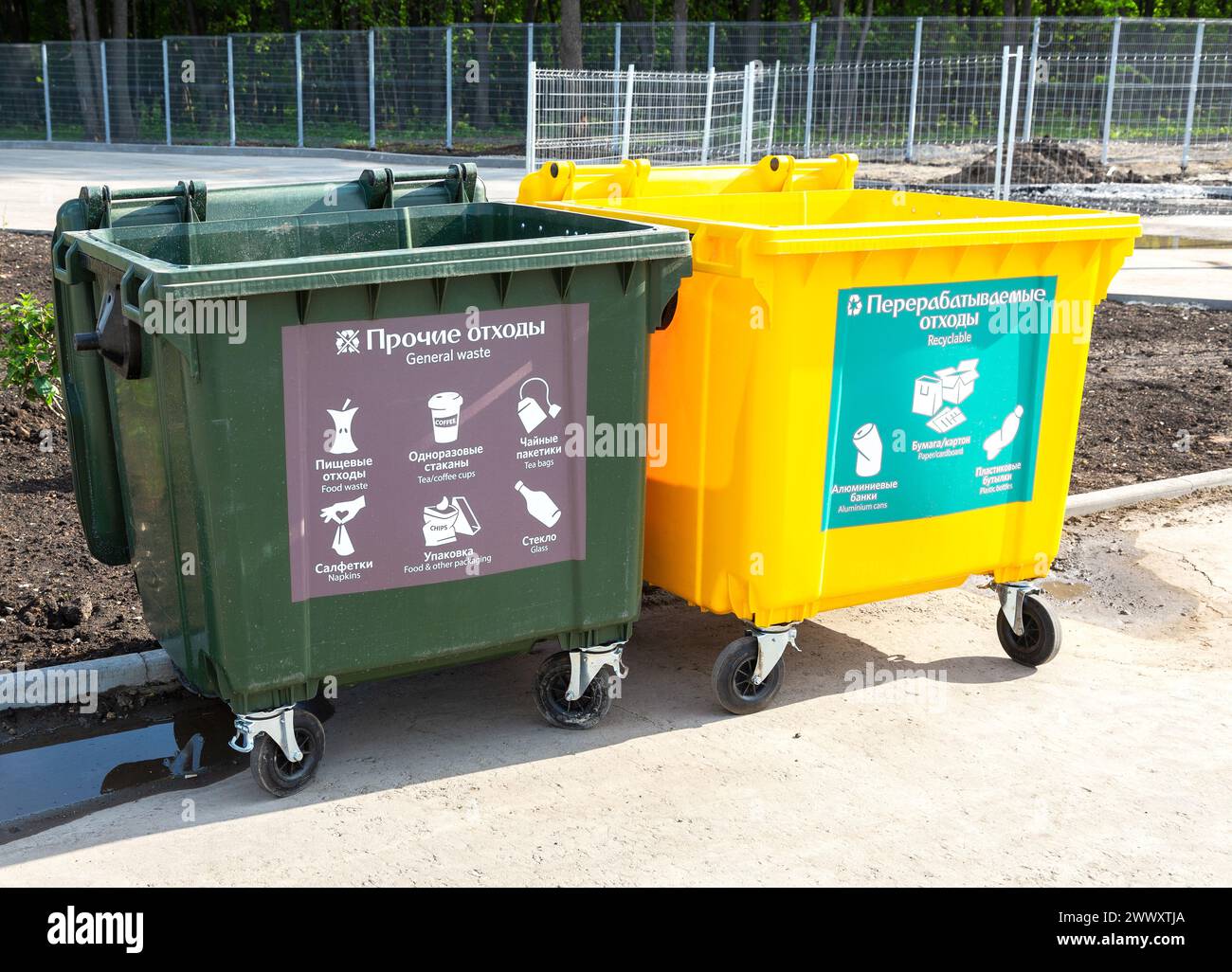 Opened plastic containers for garbage. Separate trash containers on city street. Text in russian ...