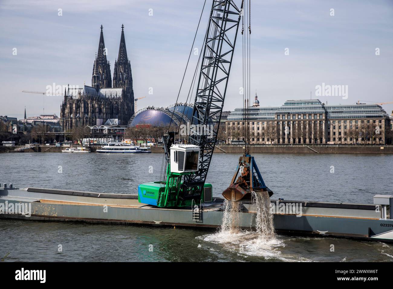 excavator on a ship deepens the riverbed of the river Rhine, the ...