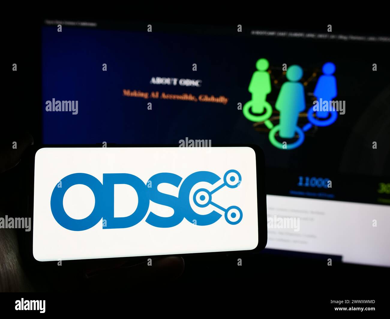 Person holding mobile phone with logo of annual event Open Data Science Conference (ODSC) in ...