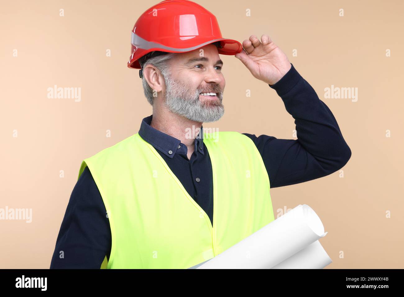Architect in hard hat holding drafts on beige background Stock Photo ...