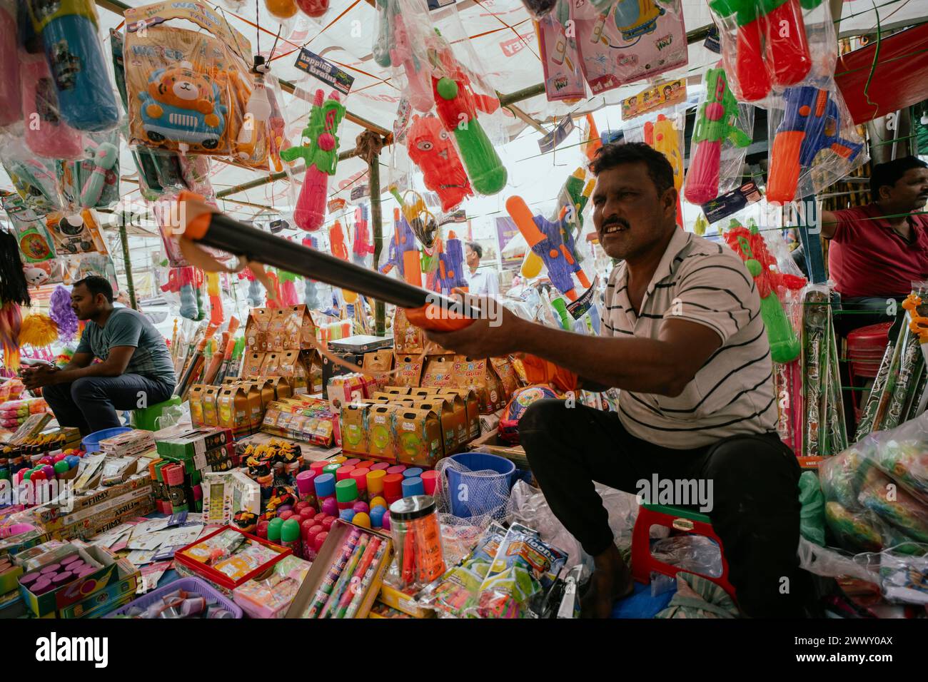 Vendor sells Holi celebration items in a street market, ahead of Holi ...