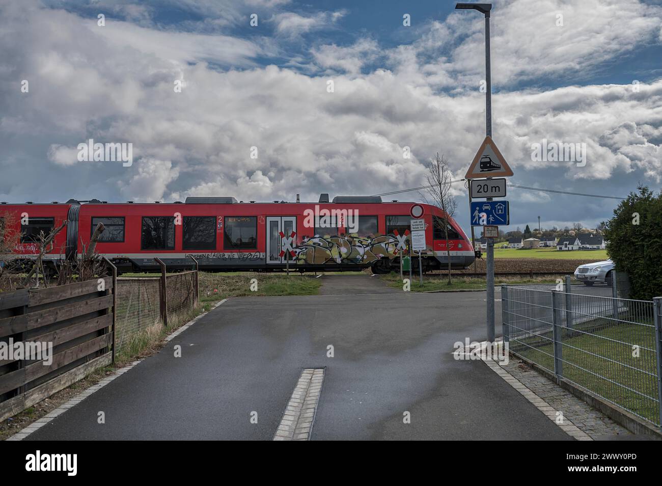 Suburban railway crossing an ungated level crossing in a village, Forth ...