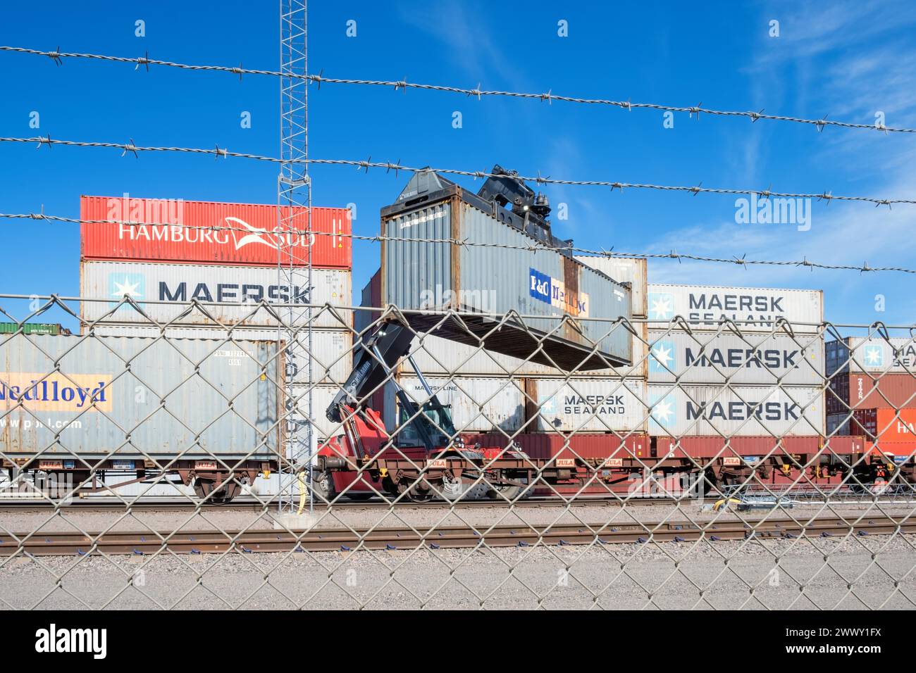 Lifting crane loading containers onto railways wagons in a dry port ...