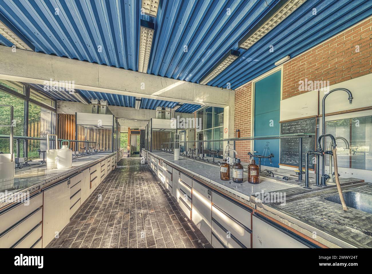 An abandoned laboratory room with long benches and glass containers ...