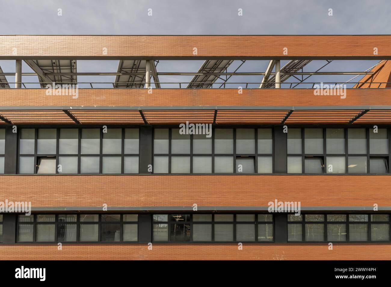 Front image of the facade of the office building with a light brown ...
