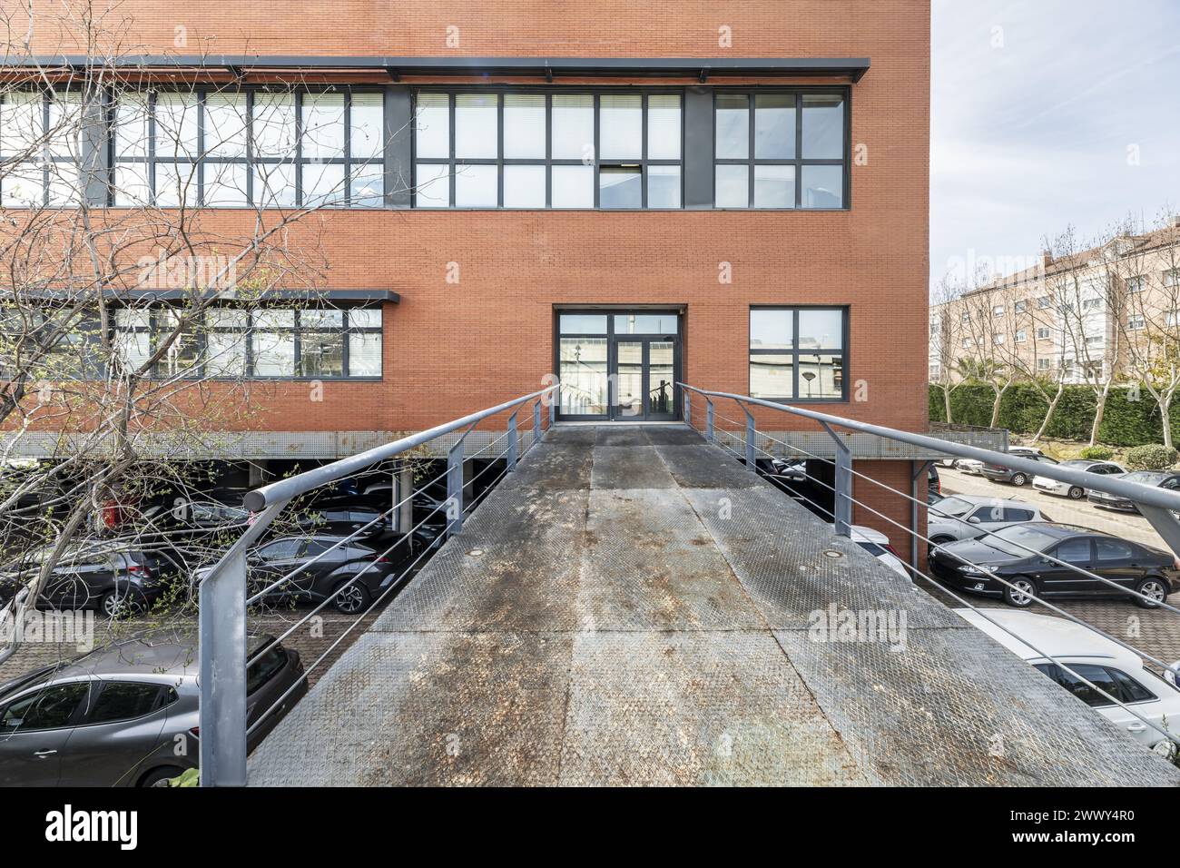 Access walkway to an office building with light brown brick walls ...