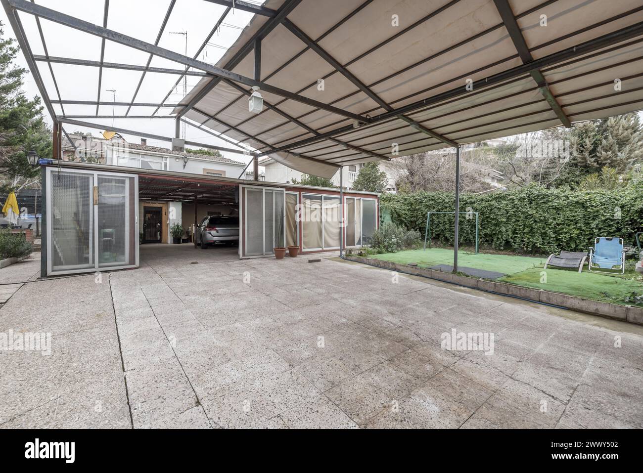 A covered terrace with a canvas roof on a metal structure and a room ...