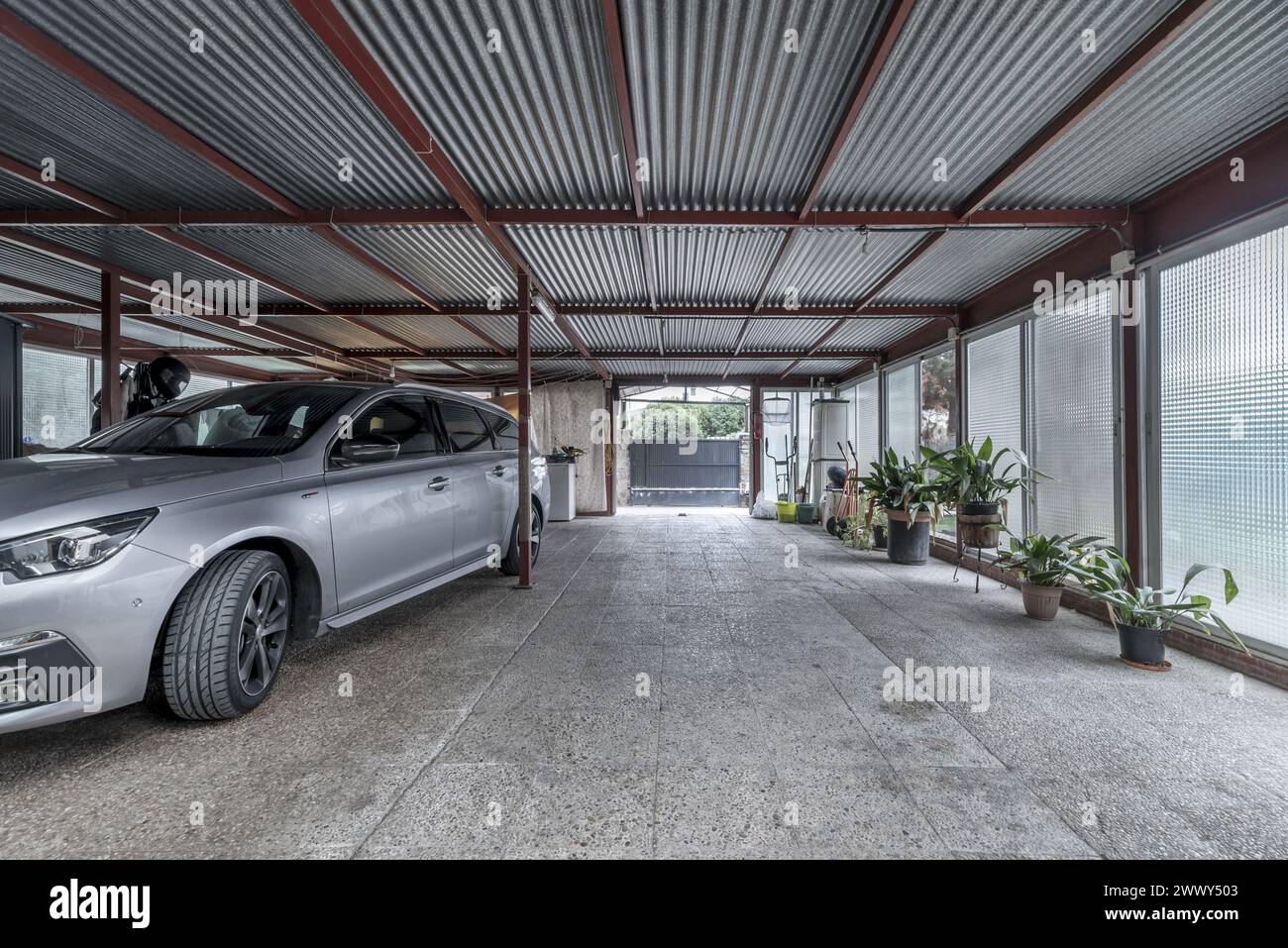 A covered terrace with corrugated metal structure and a room with ...
