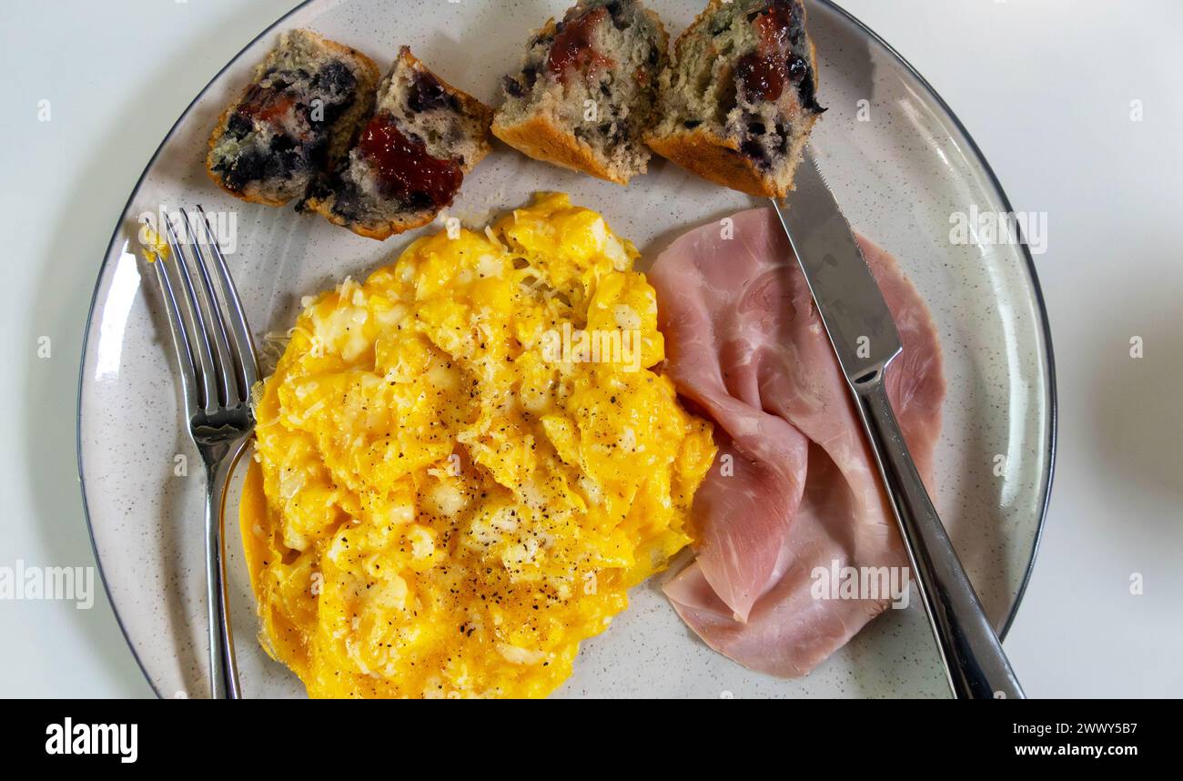 Scrambled eggs with ham and a blueberry muffin Stock Photo - Alamy