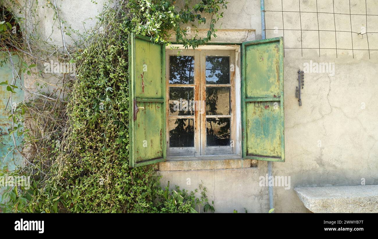 The window with metal shutters of an ancient abandoned house in the ...