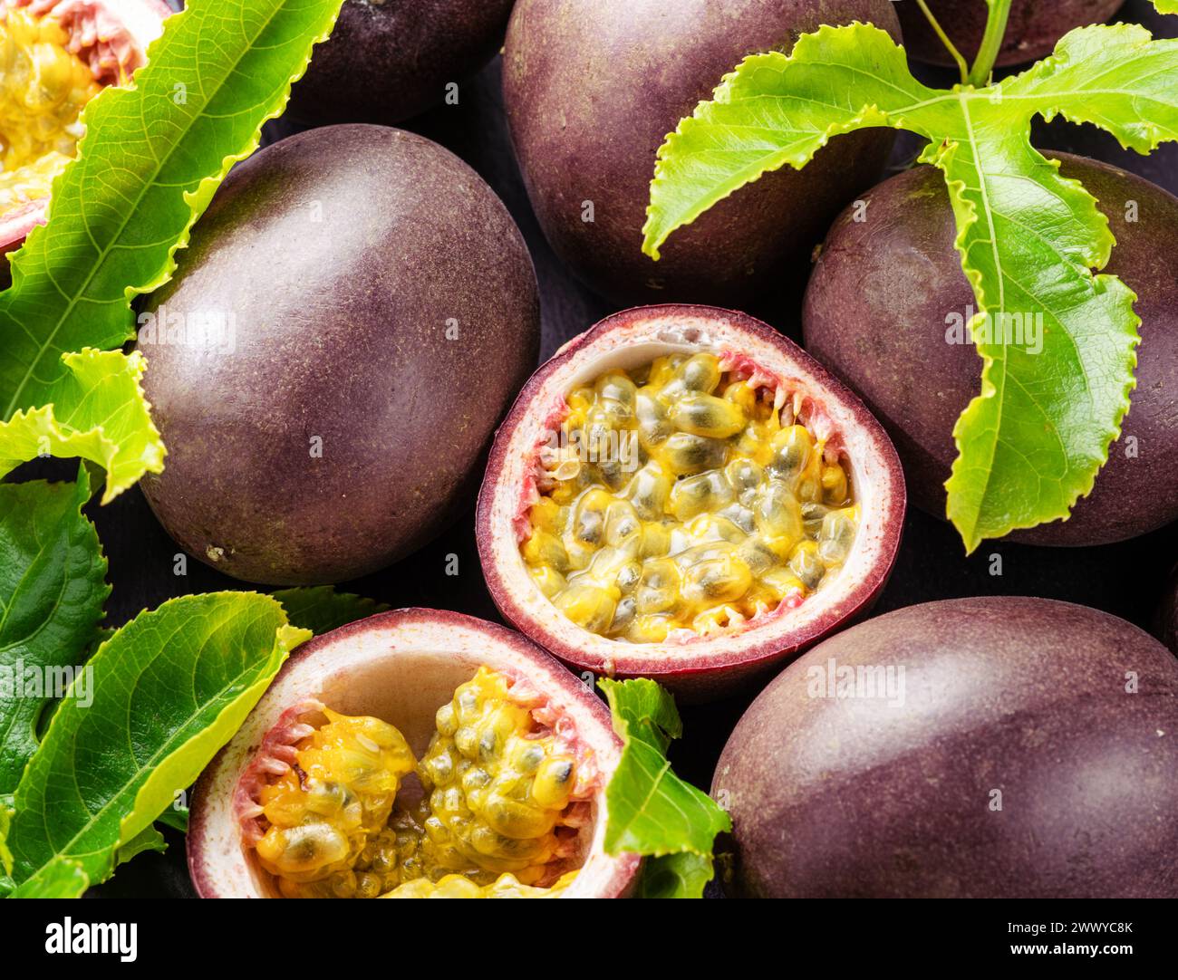 Ripe passion fruits with passion fruit seeds and passionfruit leaves on ...
