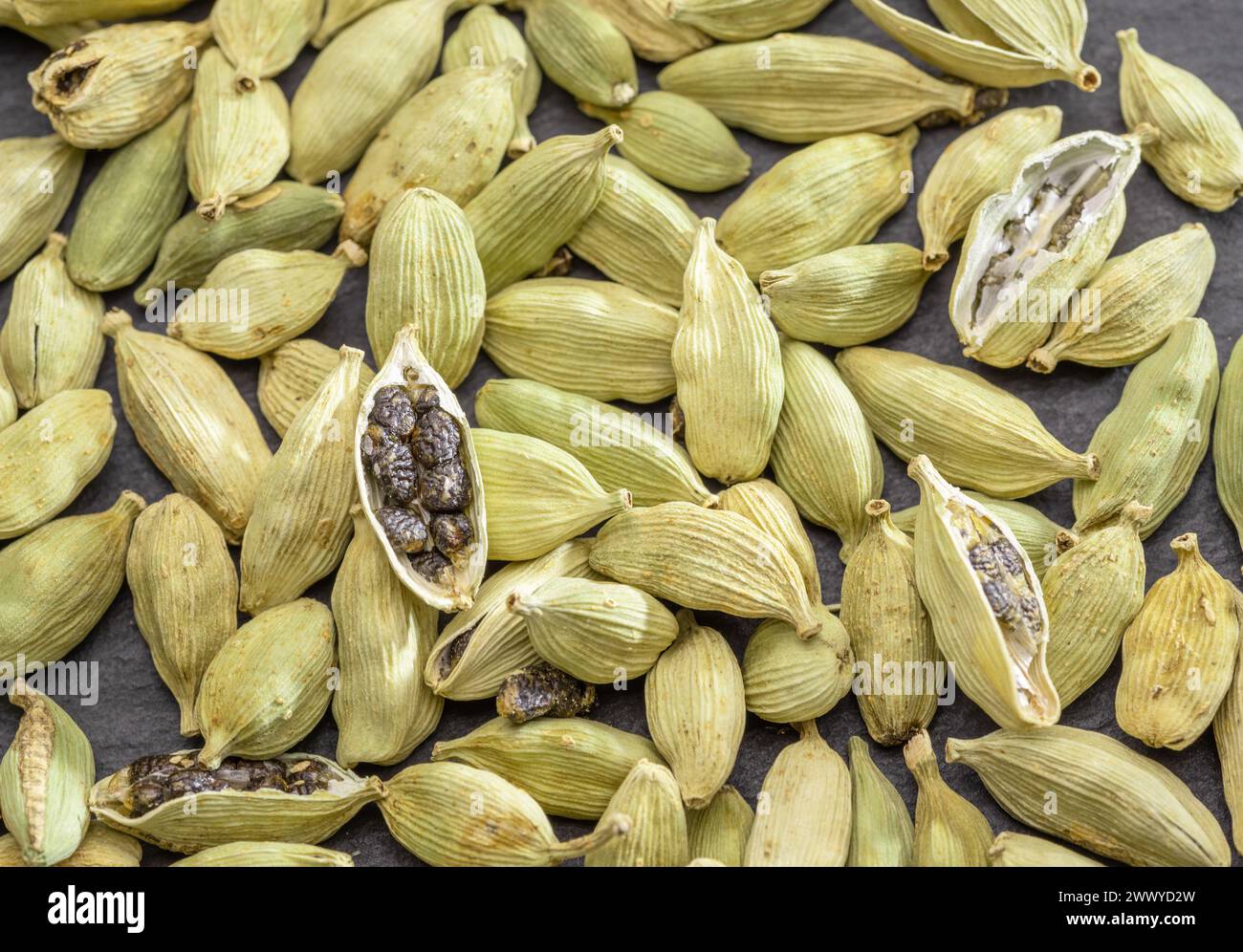 Seeds of cardamom spices on a stone table, mulled wine ingredient ...