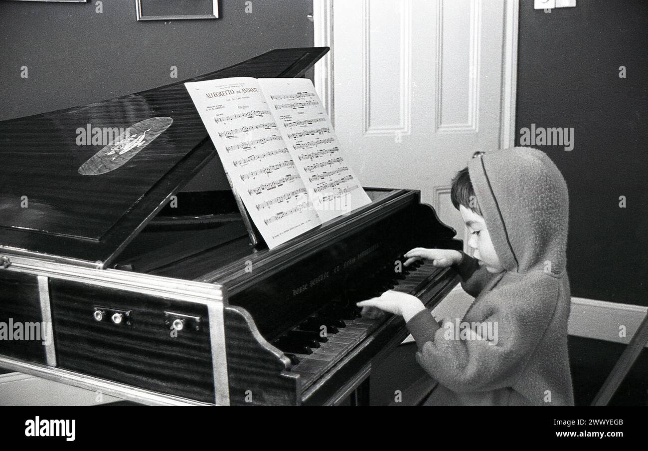 1970s, historical, a young boy in a hooded fleece top sitting playing a ...