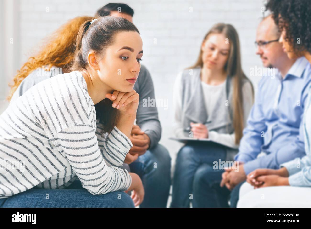 Stressed thoughtful woman during group rehab therapy Stock Photo - Alamy
