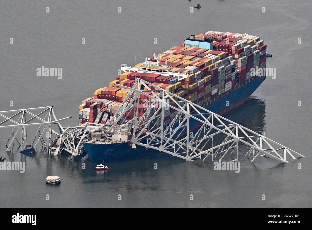 A damaged container ship rests next to a bridge pillar in the Patapsco ...