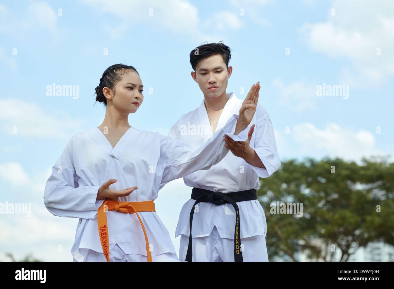 Taekwondo instructor explaining girl how to keep arms up when doing ...