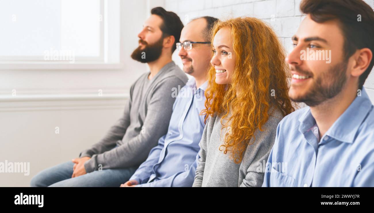 Happy people sitting in a row and listening speaker during workshop ...