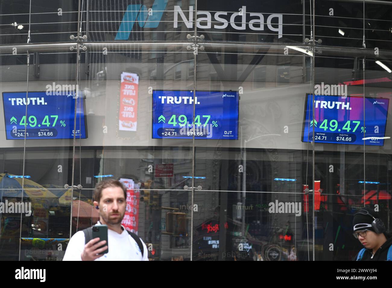 New York, USA. 26th Mar, 2024. Pedestrians walk past the Nasdaq ...