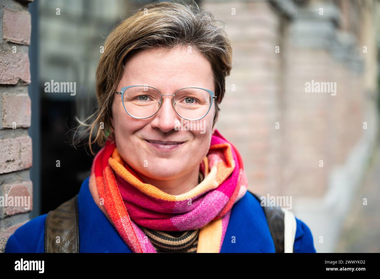 Outdoor portrait of a 38 yo white woman leaning against a wall ...