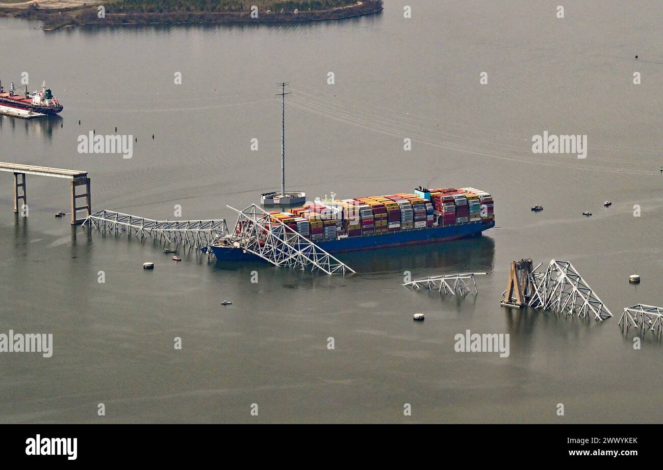 A damaged container ship rests next to a bridge pillar in the Patapsco ...