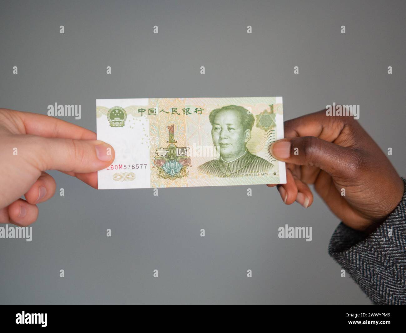 Two hands holding a one yuan note Stock Photo - Alamy