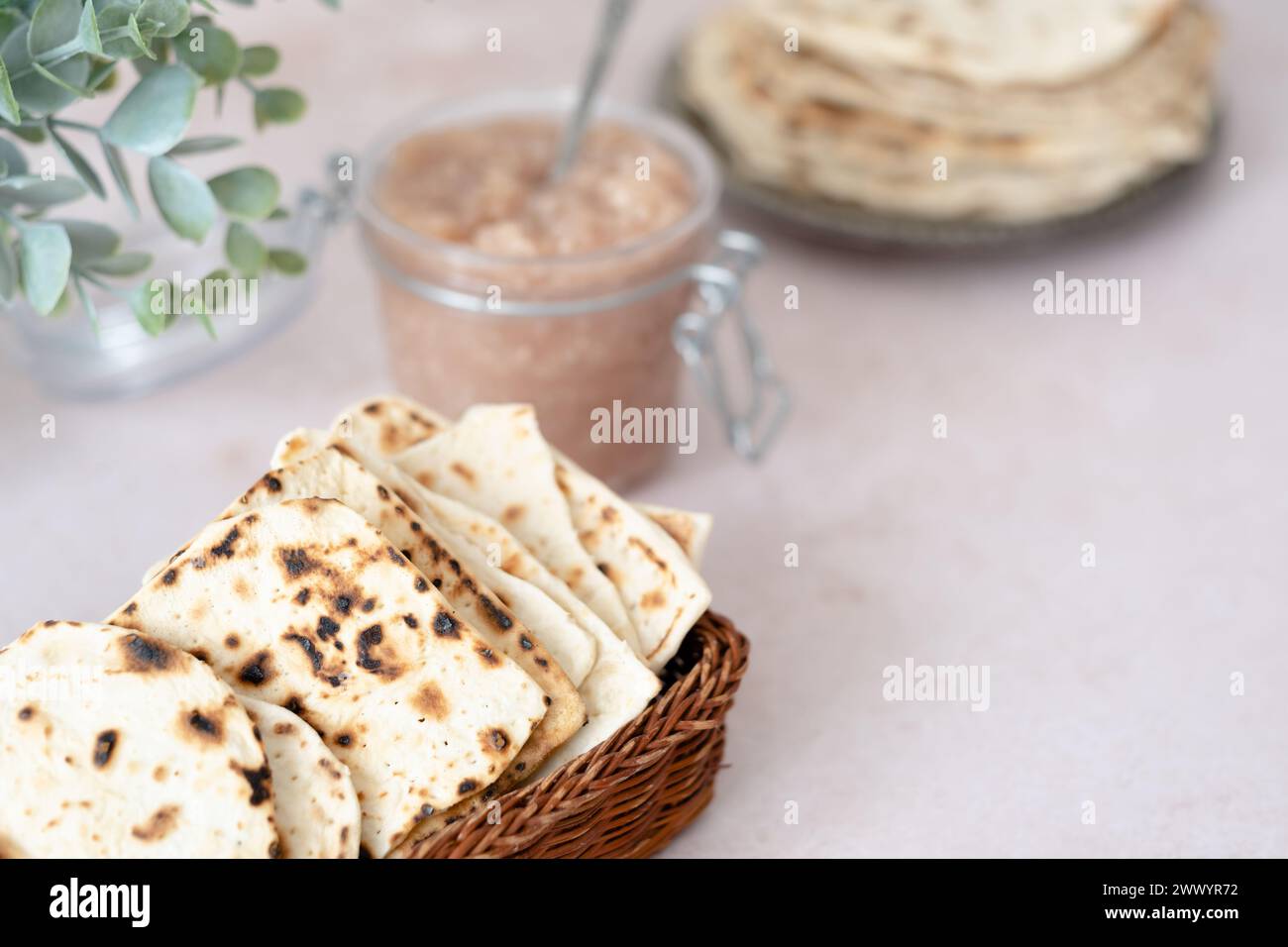 Handmade matzo in a wicker basket. Sweet condiment with apple-walnut ...