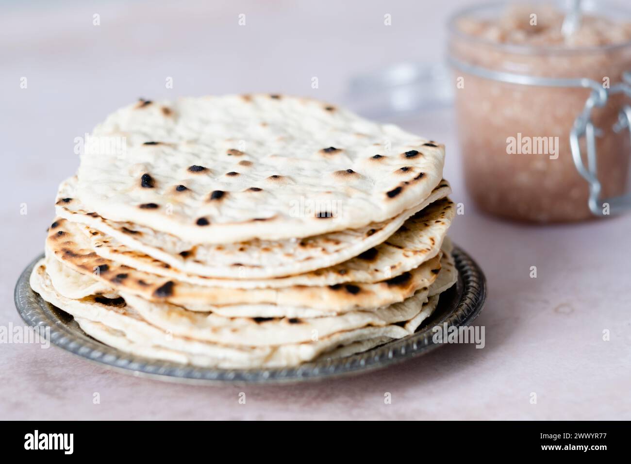 Handmade round matzo in a plate. Sweet condiment with apple-walnut ...