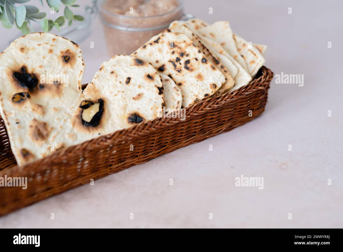 Handmade matzo in a wicker basket. Sweet condiment with apple-walnut ...