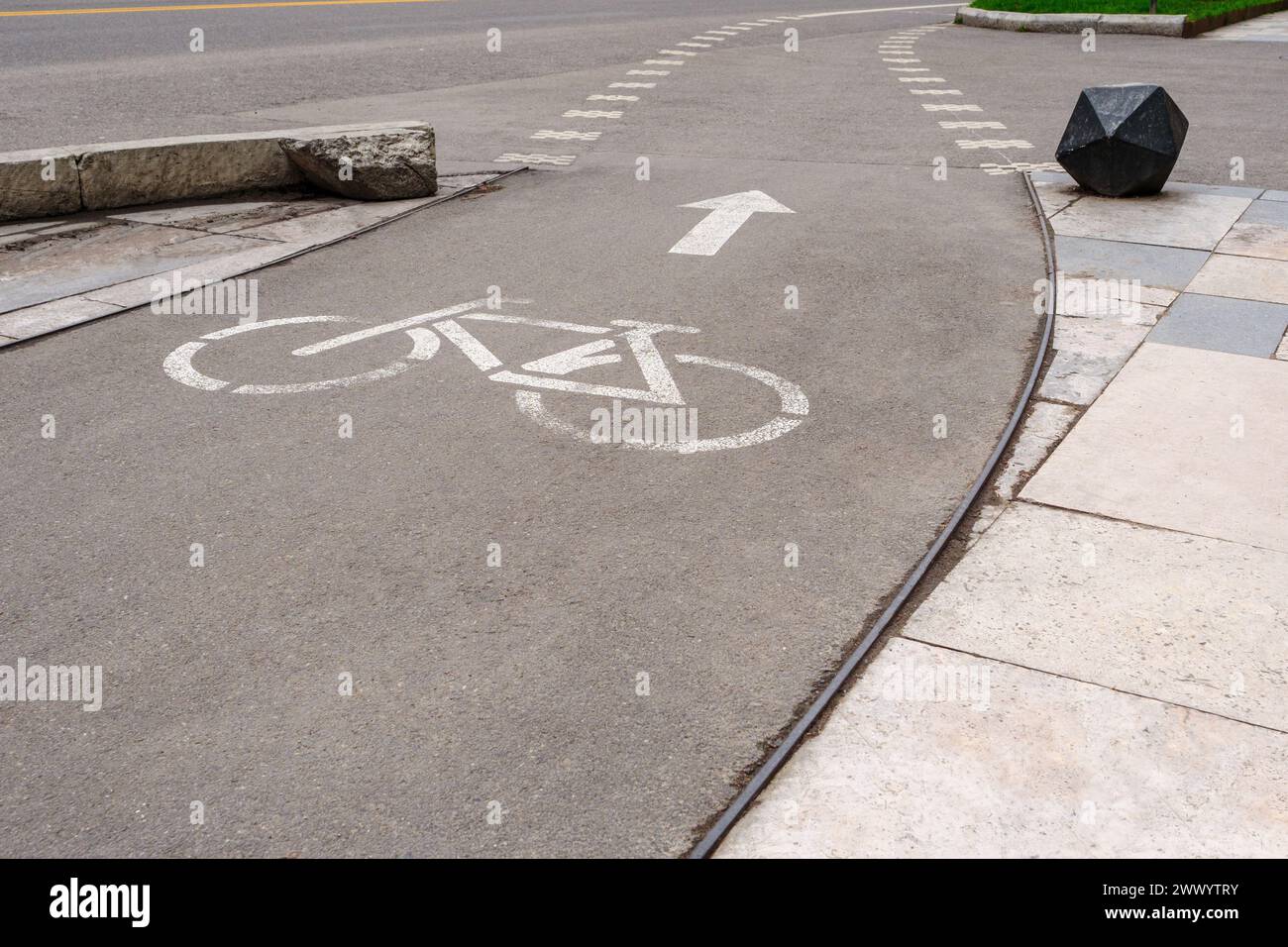 A white bicycle symbol with an arrow, indicating a designated bike lane ...
