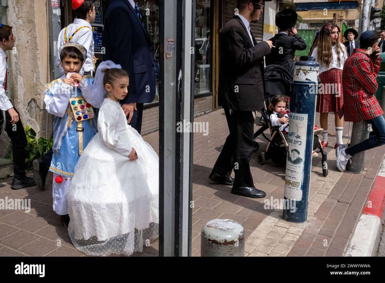 A girl is seen dressed in a white dress as Queen Esther and a boy next ...