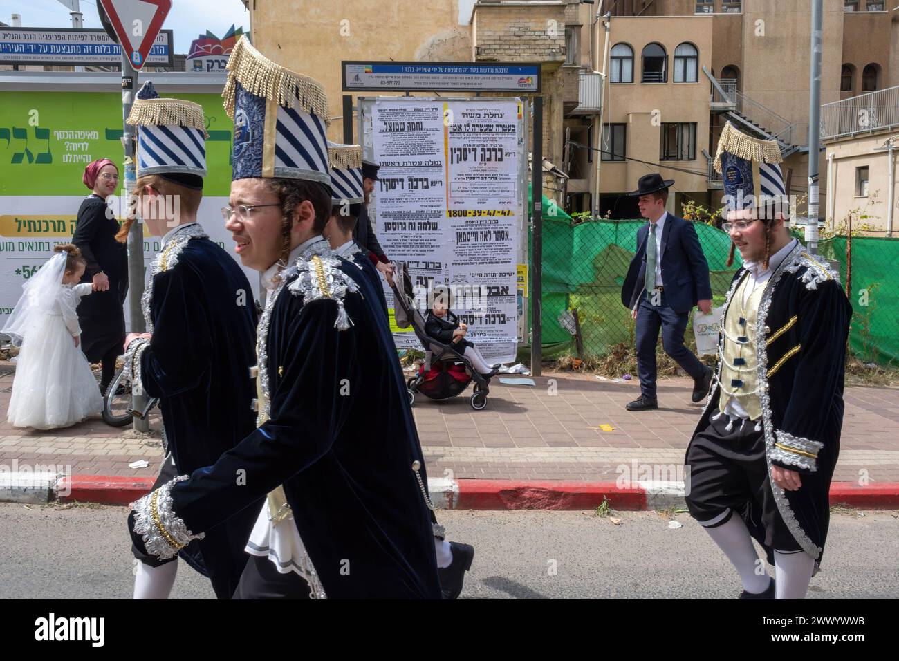 Young men seen dressed in costumes walk on the streets during the Purim ...