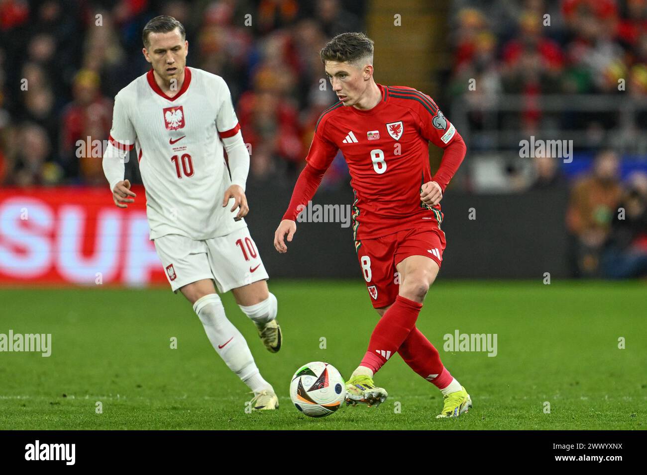 Aaron Ramsey of Wales passes the ball pressured by Piotr Zieliński of ...