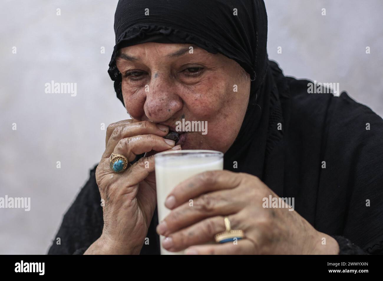 Baghdad, Iraq. 26th Mar, 2024. Umm Hassan, 71, eats dates and drinks ...