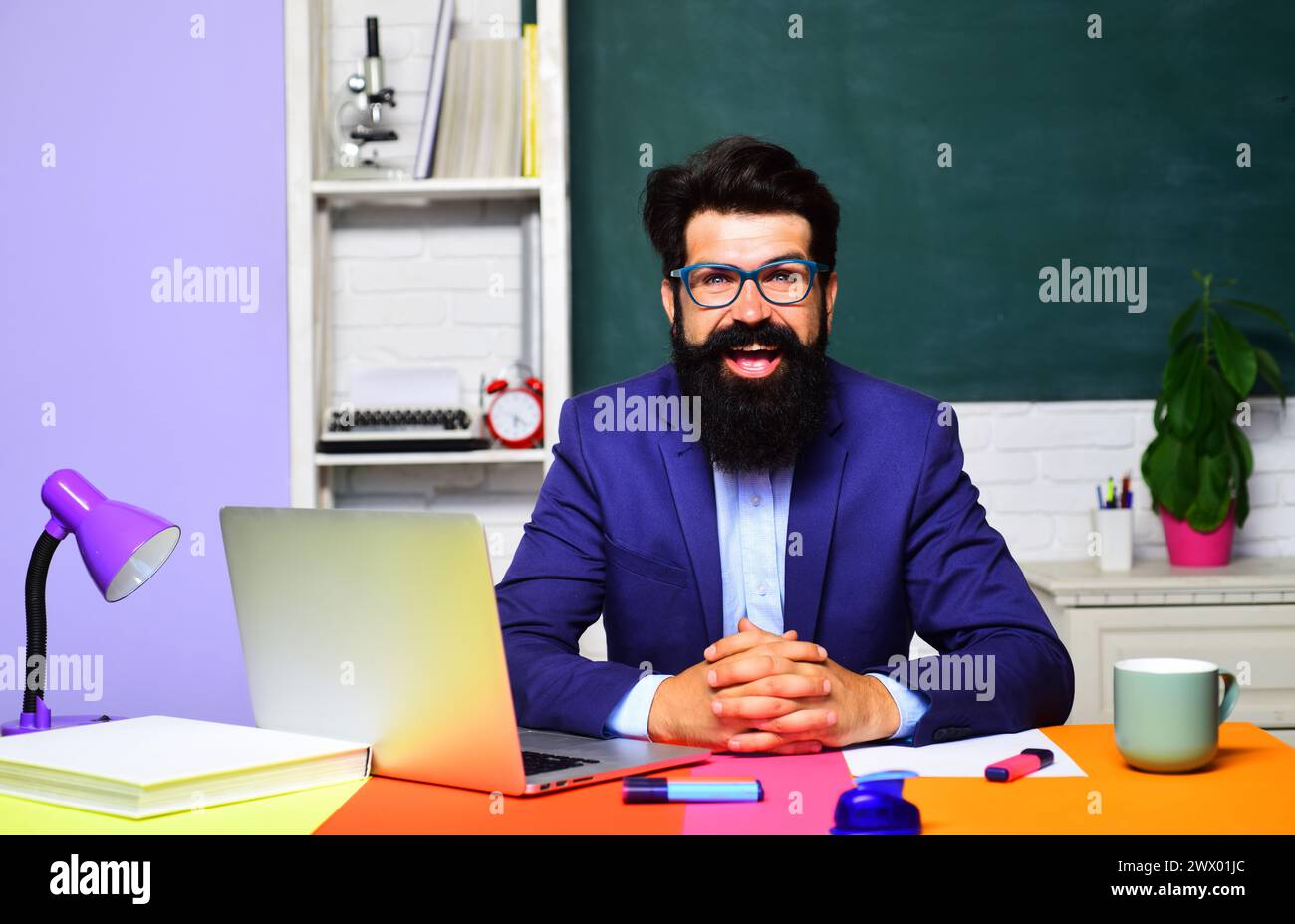 Smiling male teacher or student in glasses in classroom. School teacher ...