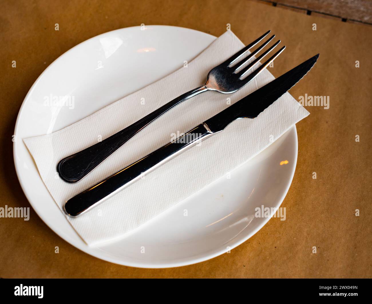 Empty plate and cutlery. Dining table in restaurant Stock Photo - Alamy